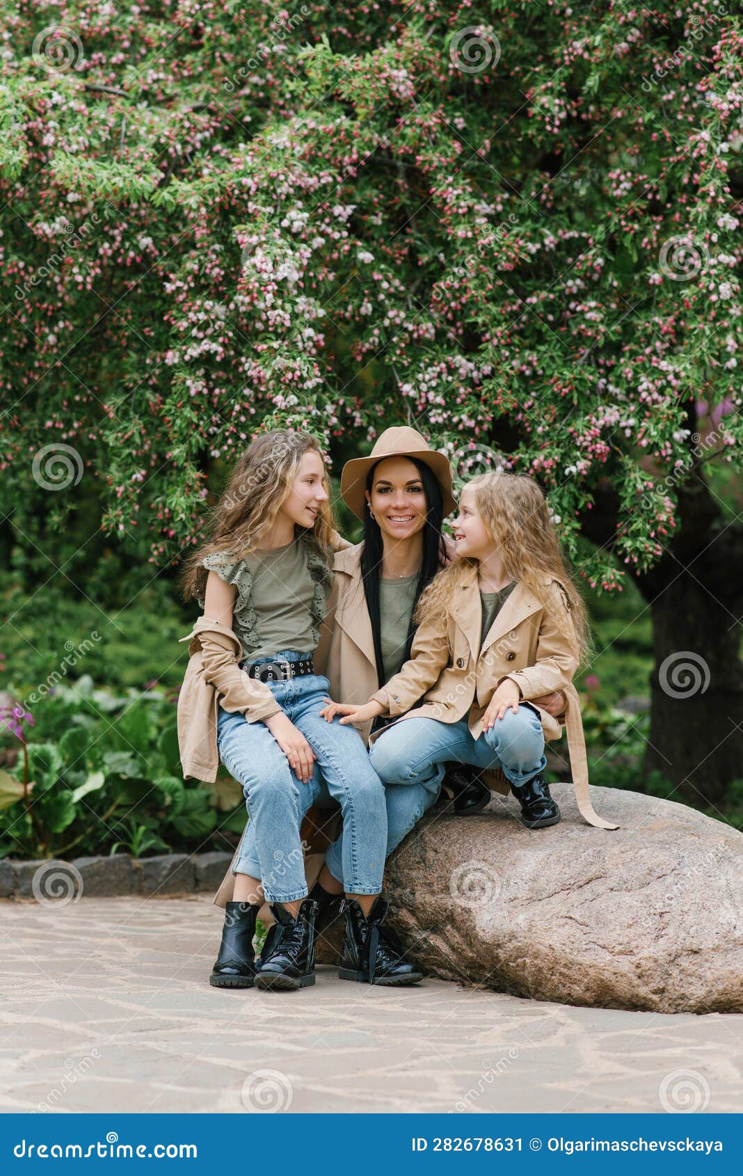 Stylish Caucasian Mom And Her Two Daughters Are Chatting And Walking In
