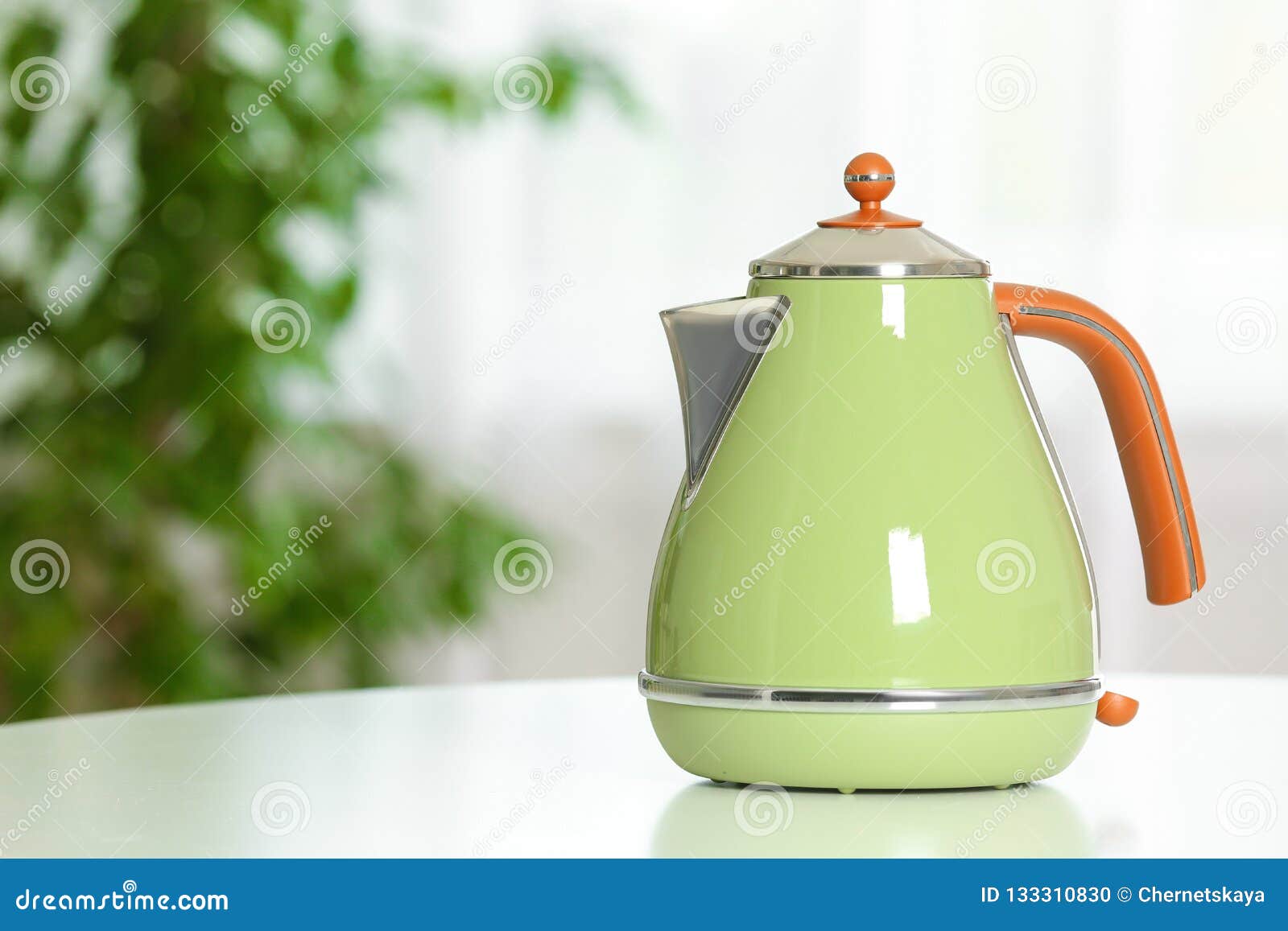 Stylish Electrical Kettle on Table Against Blurred Room Interior. Stock ...