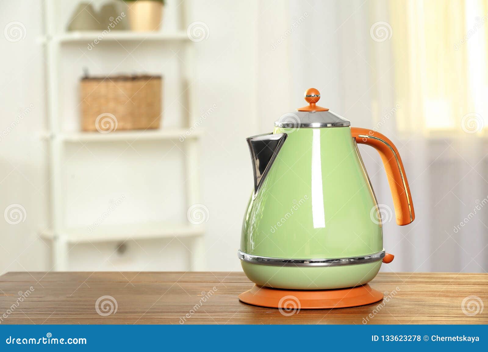 Stylish Electrical Kettle on Table Against Blurred Room Interior. Stock ...