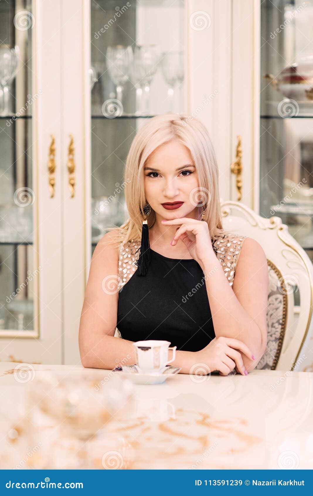 Stylish Elegant Blonde Woman In Beauty Rich Interior Wearing Black