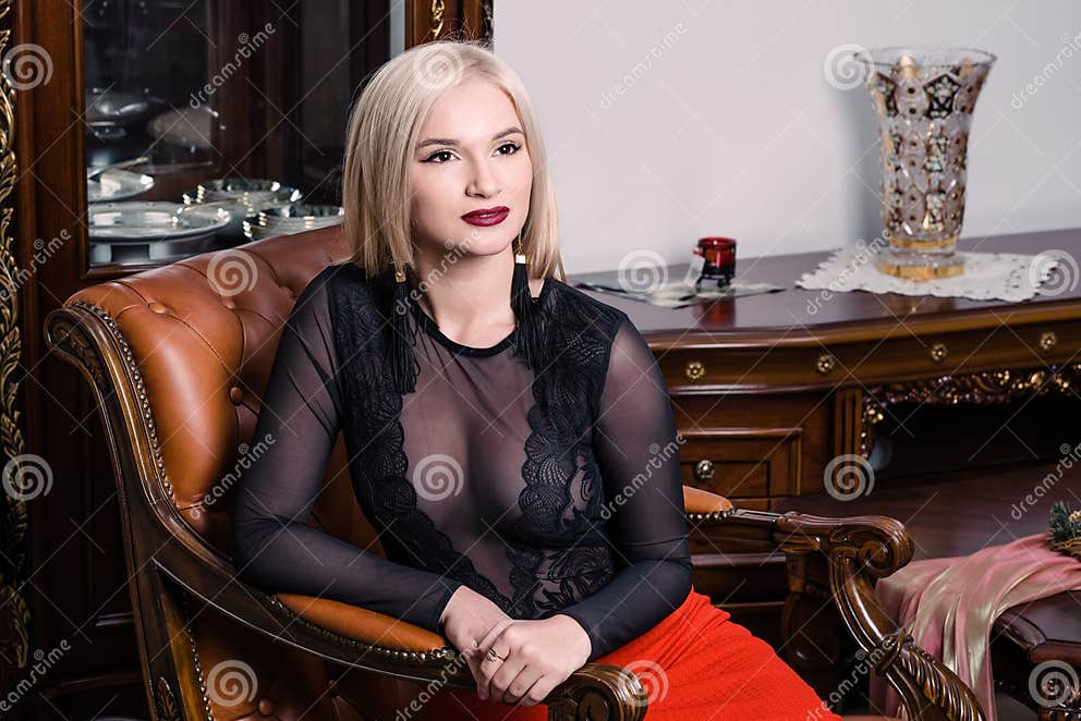 Stylish Elegant Blonde Woman In Beauty Rich Interior Wearing Black