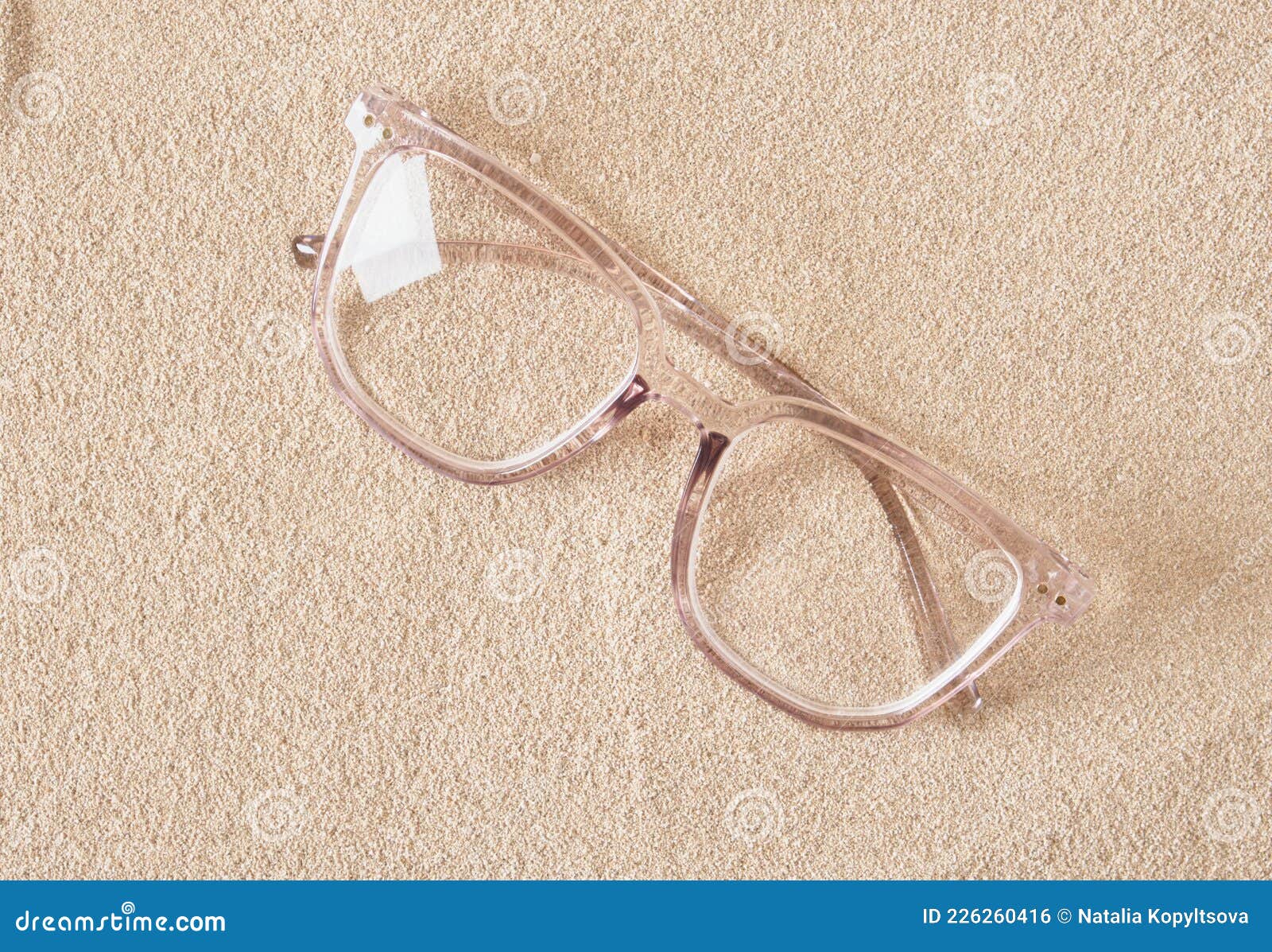 Stylish Eye Glasses in a Transparent Plastic Frame on the Sand Stock ...