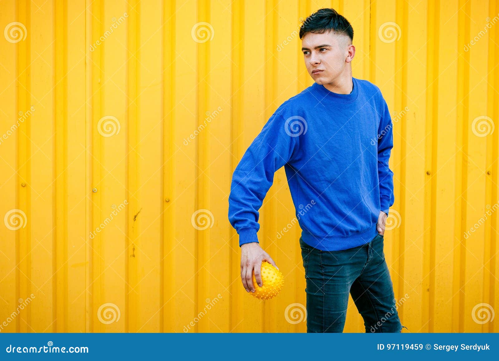 Stylish Guy in Blue Sweater with Yellow Ball Stock Image - Image of ...