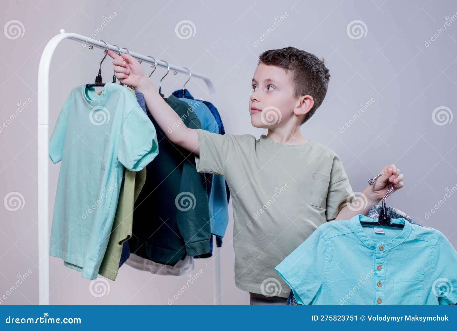 A Stylish Little Preschool Boy is Standing by the Clothes Rack, Looking ...