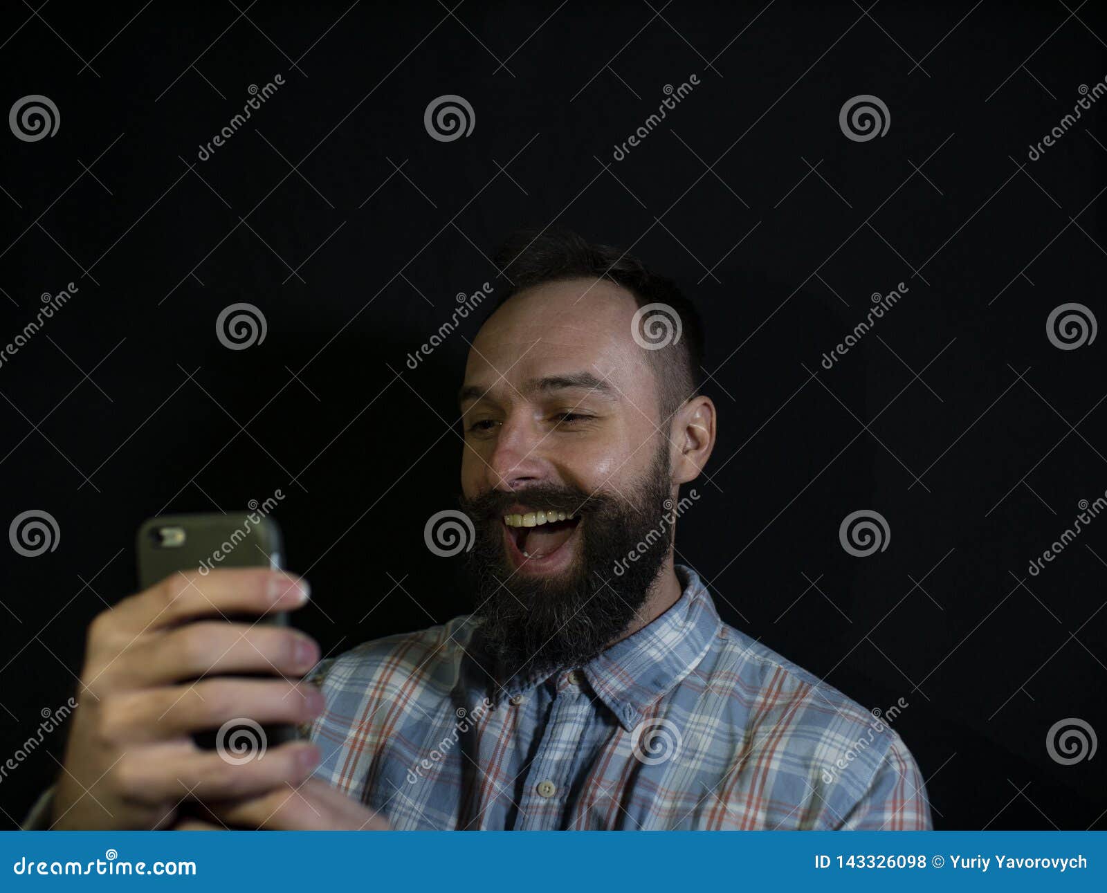 Stylish Man With A Beard And Mustache Looks Into A Mobile Phone With A
