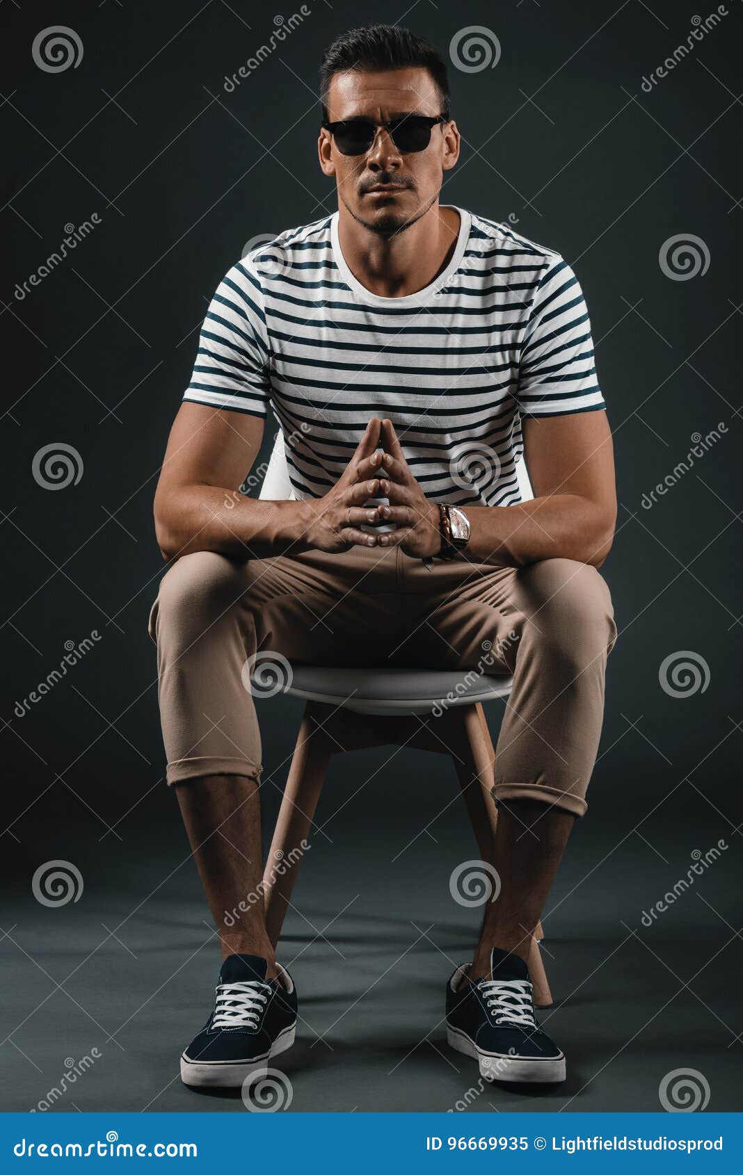 Stylish Man in Sunglasses Sitting on Stool and Looking at Camera Stock ...