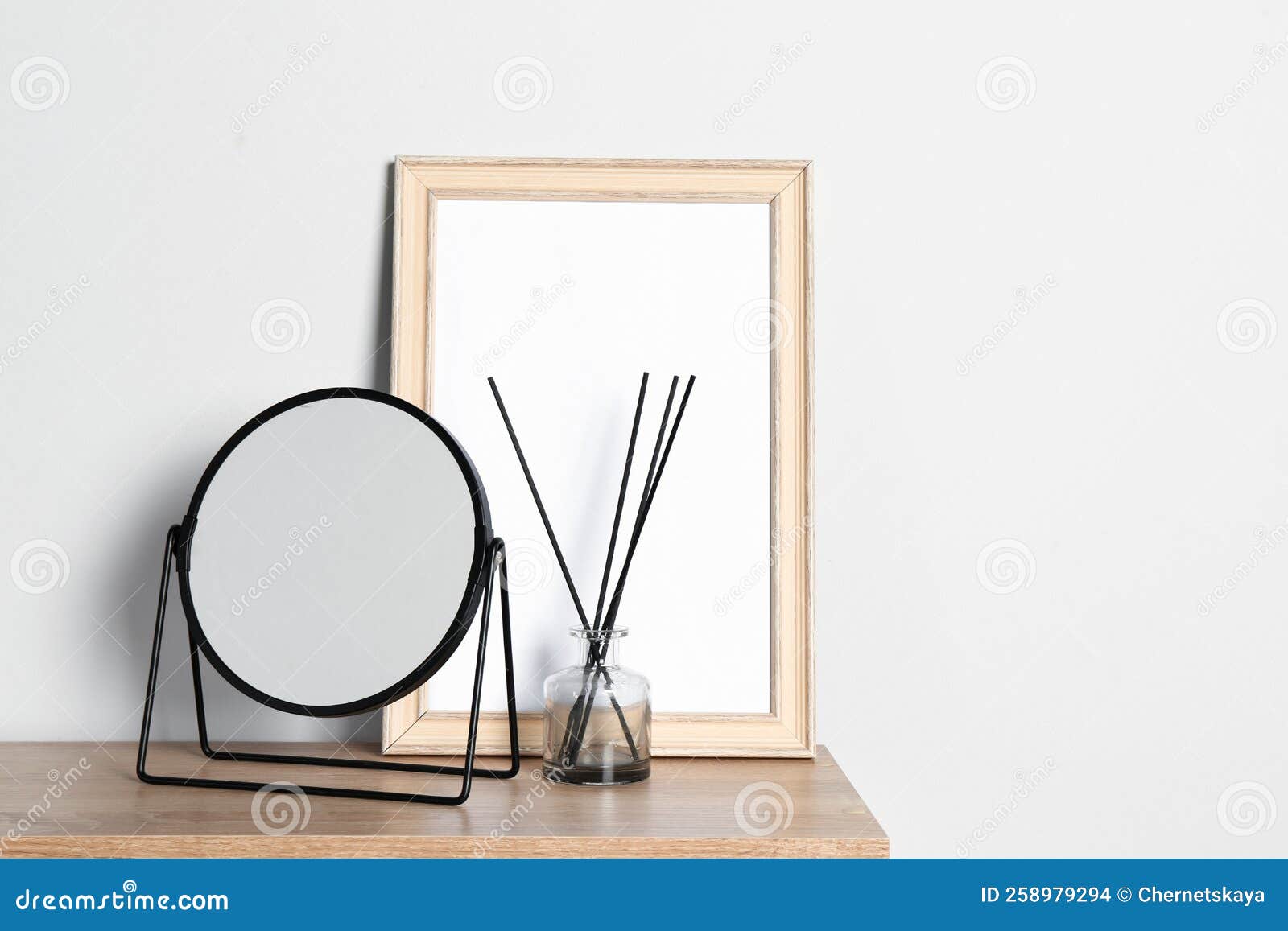 Stylish Mirror, Reed Diffuser and Picture Frame on Table Near Light ...