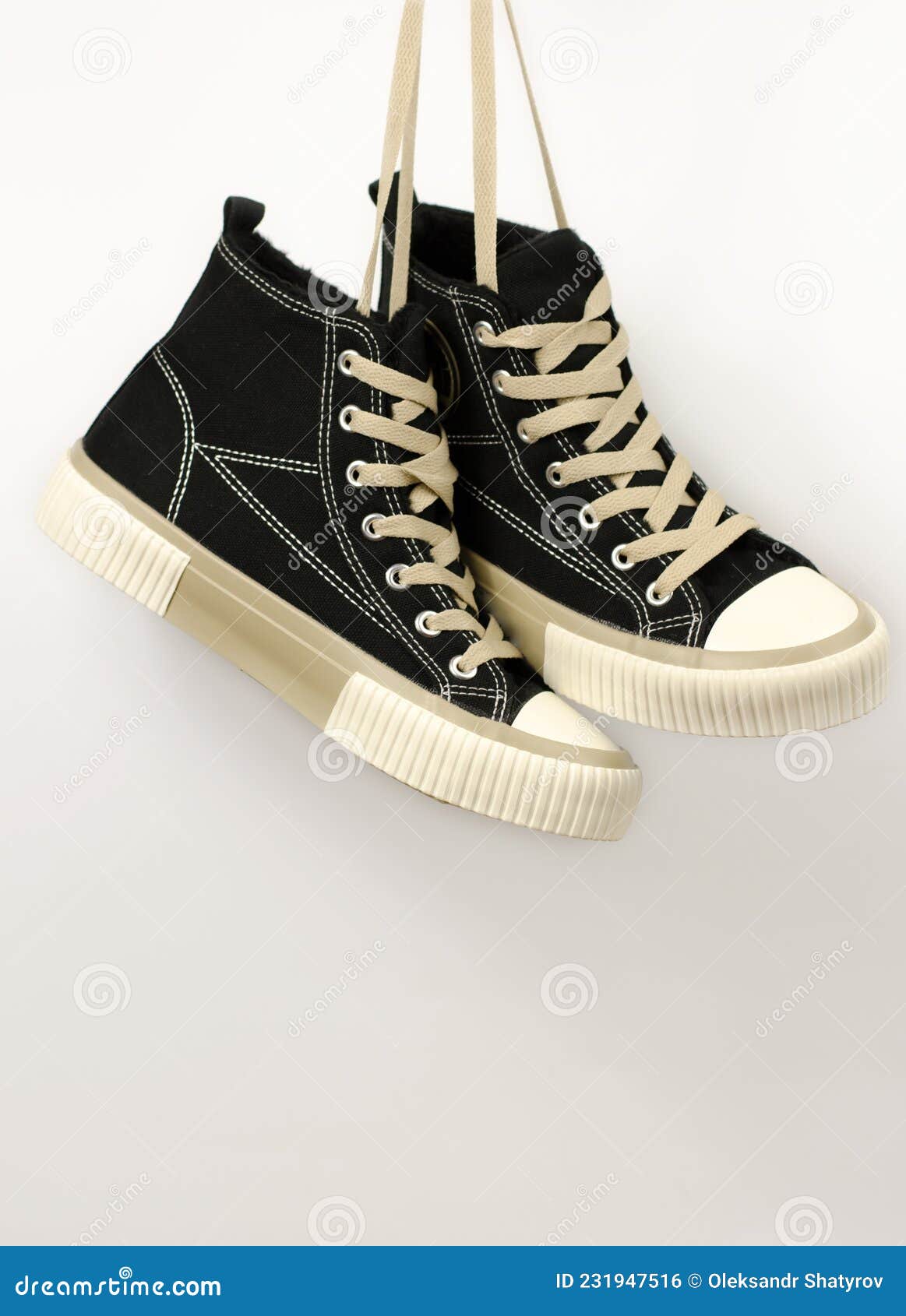 Stylish Sneakers Hang on Laces on a White Wall Stock Photo - Image of ...