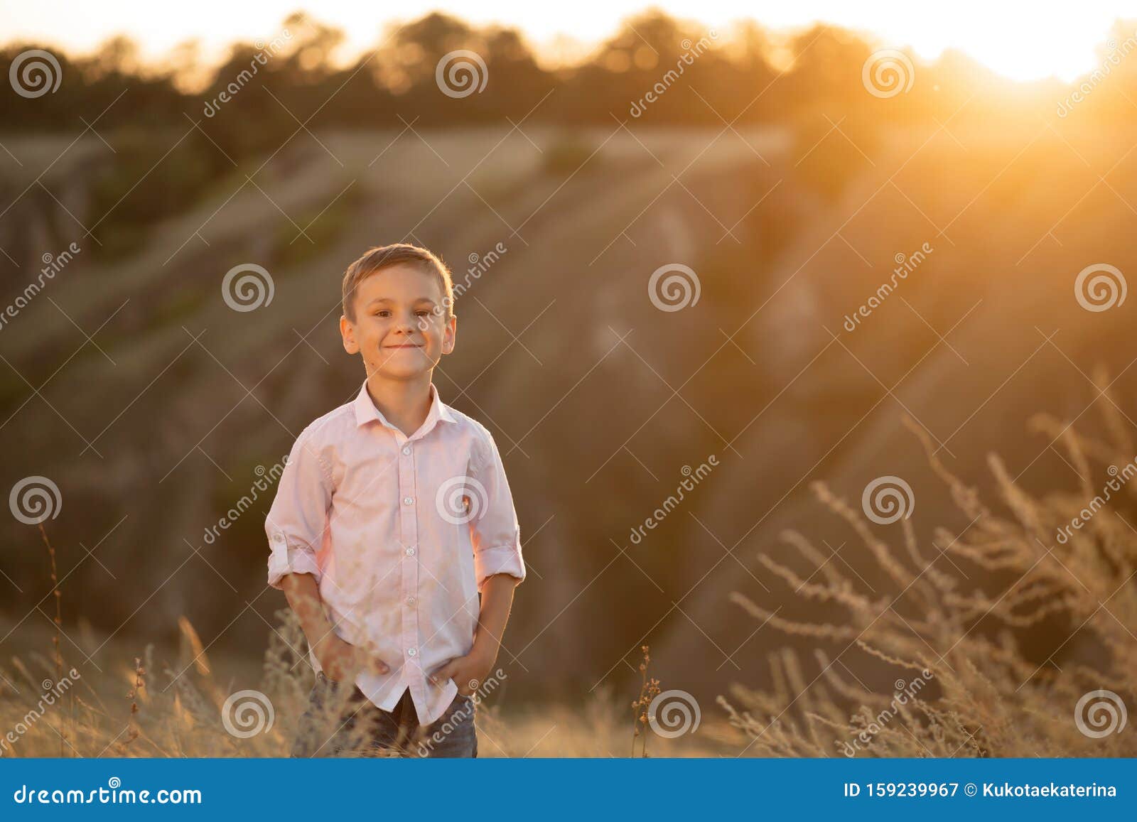 Stylish Young Boy Posing in Field at Sunset Stock Image - Image of ...