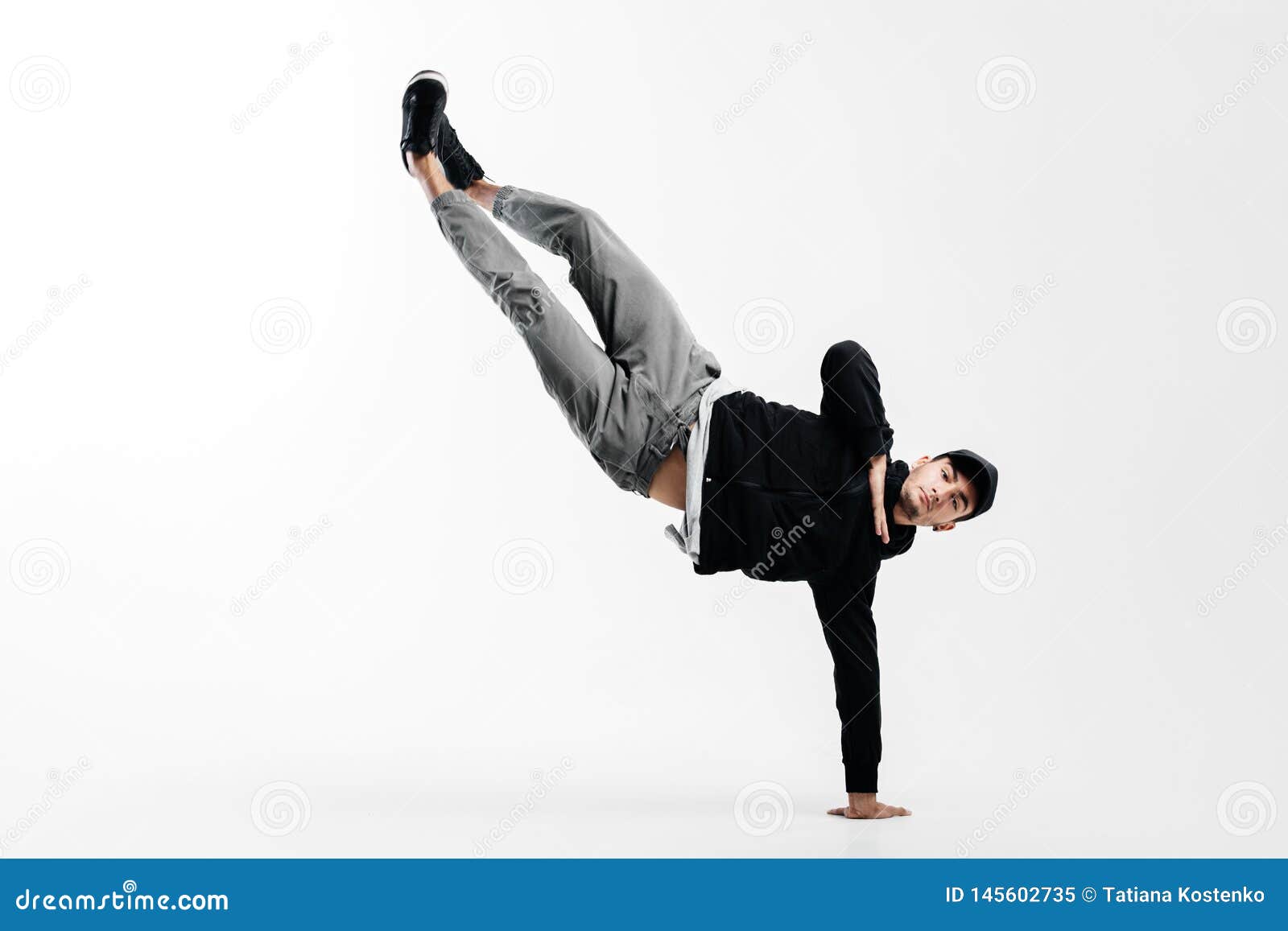 Stylish Young Man is Dancing Breakdance. he is Standing on One Arm and ...
