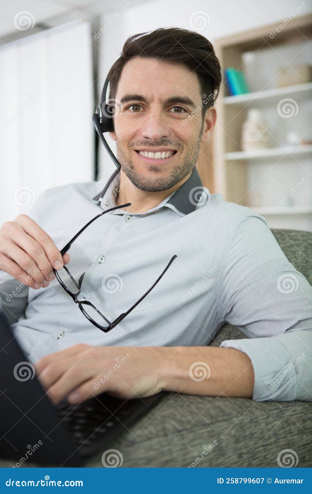 Suave Man Sat on Sofa Using Headset and Laptop Computer Stock Image ...