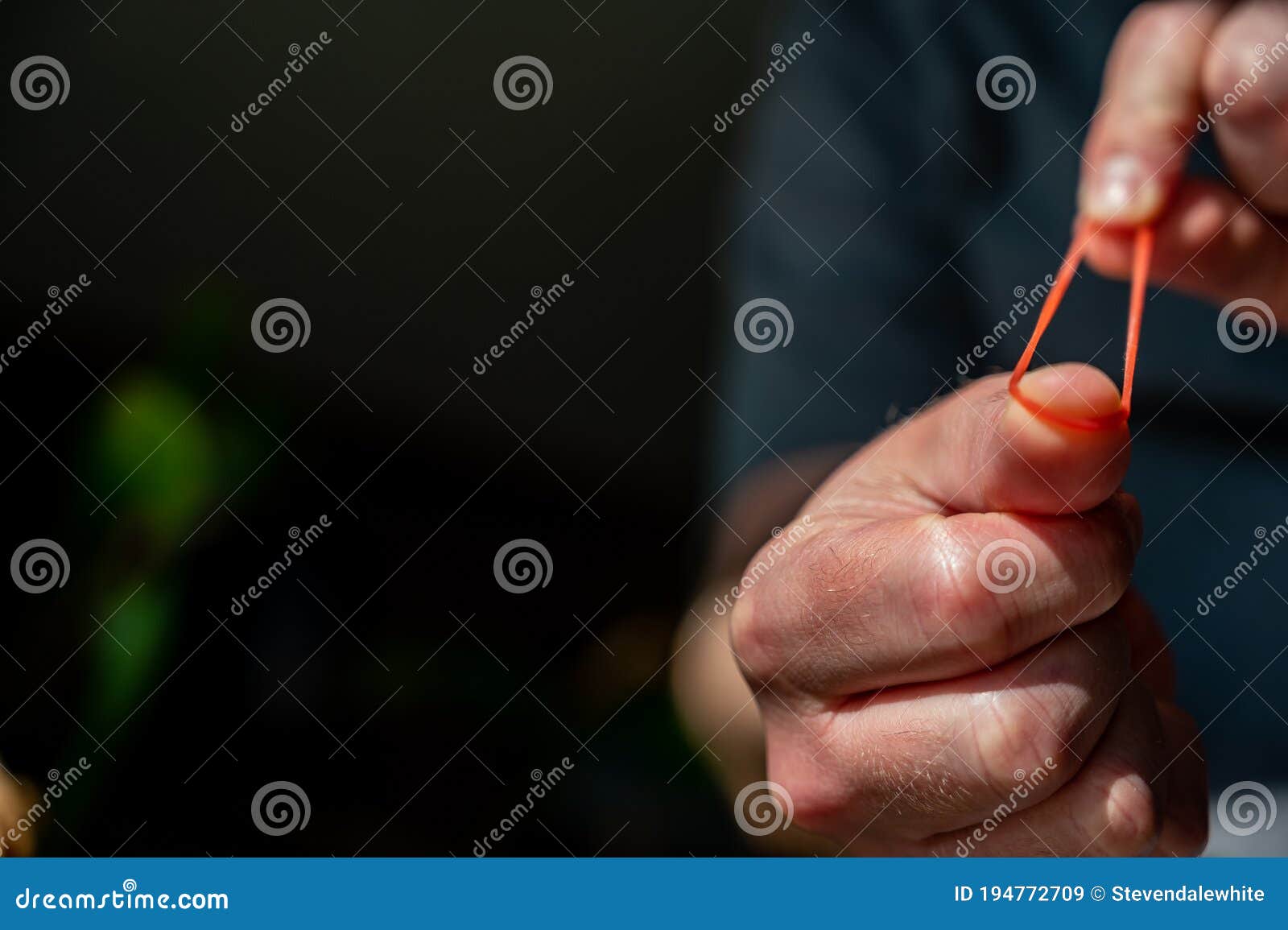 Subjective Focus on Rubber Band Pulled Taunt Being Aimed at the Camera ...