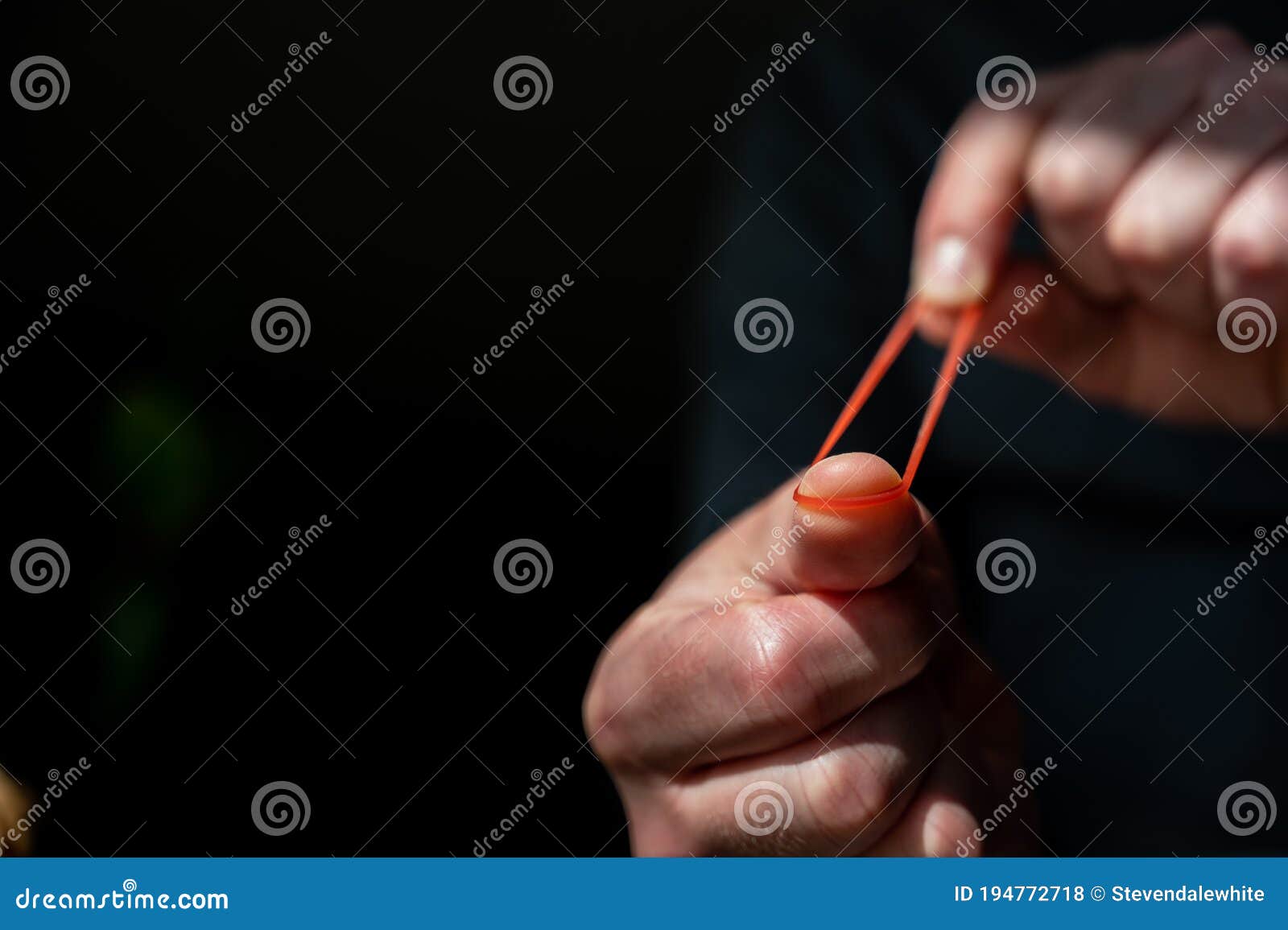 Subjective Focus on Rubber Band Pulled Taunt Being Aimed at the Camera ...