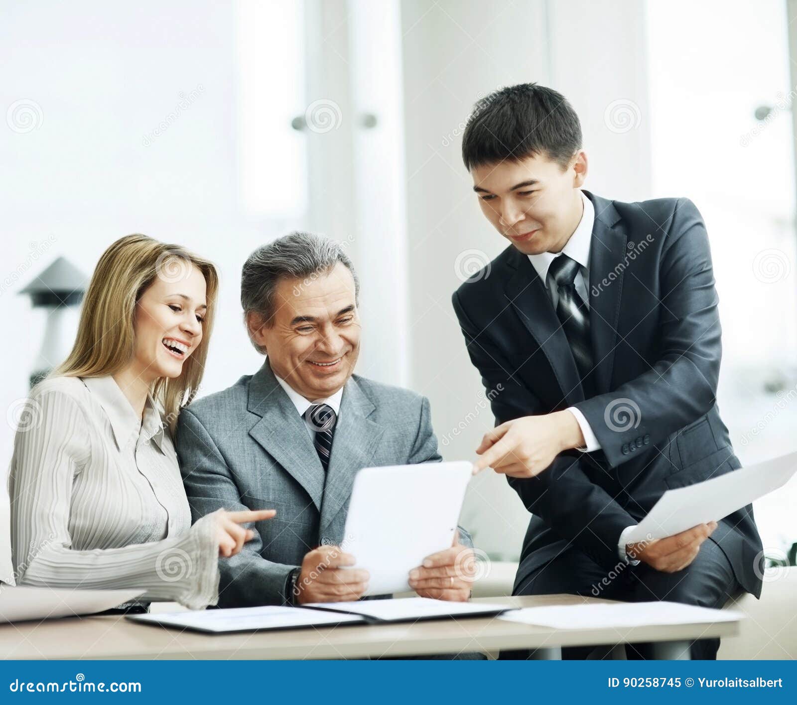 A Successful Business Group Discusses a Work Plan Using a Tablet Stock ...