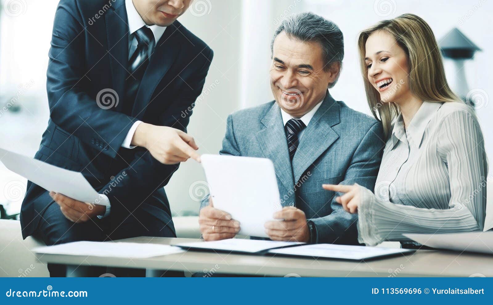 A Successful Business Group Discusses a Work Plan Using a Tablet Stock ...