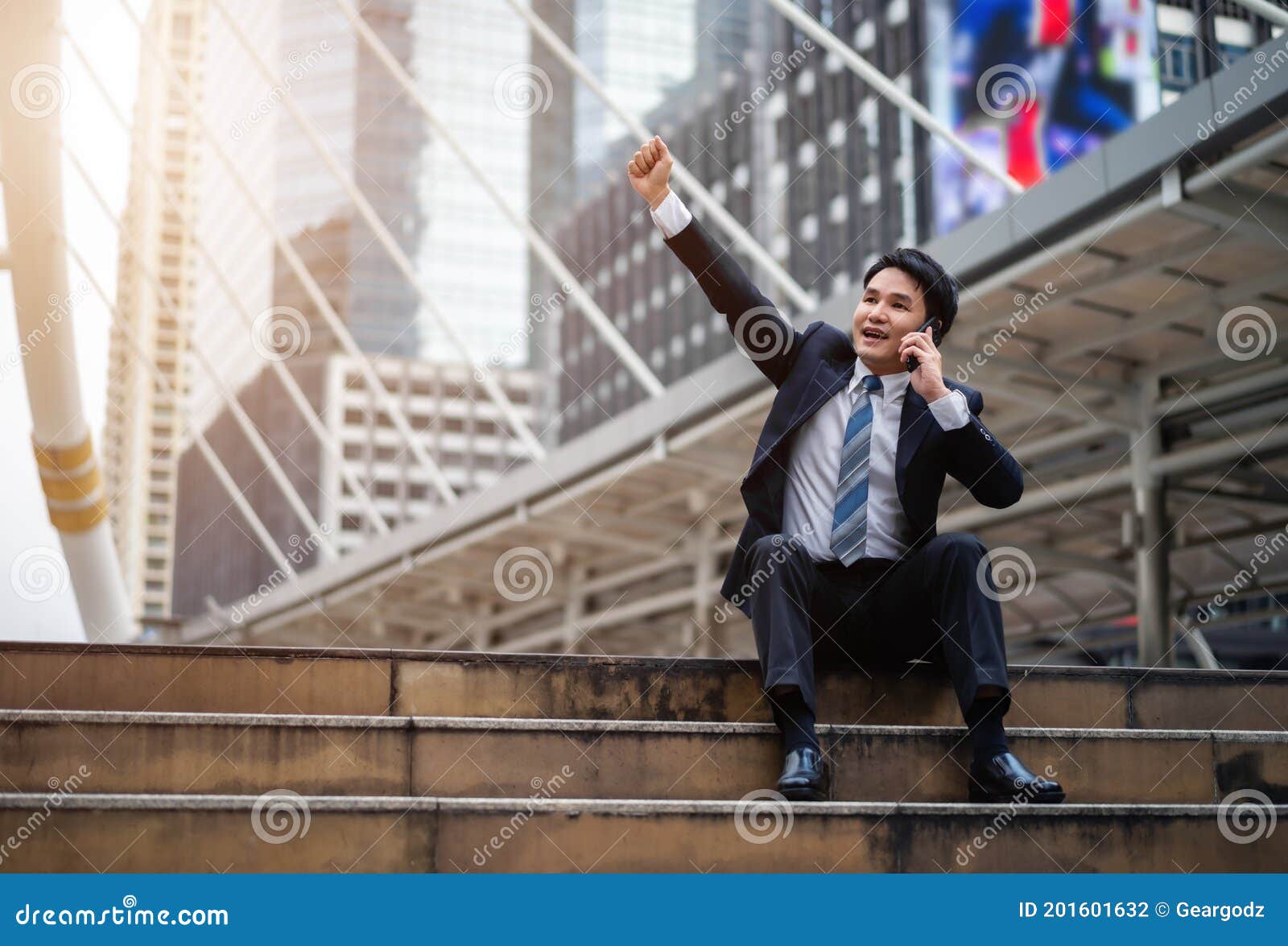 Successful Business Man Talking a Mobile Phone with Arm Raised in City ...