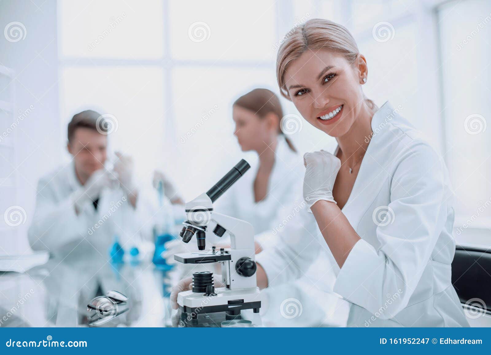 Successful Female Scientist Sitting in Front of a Microscope Stock ...