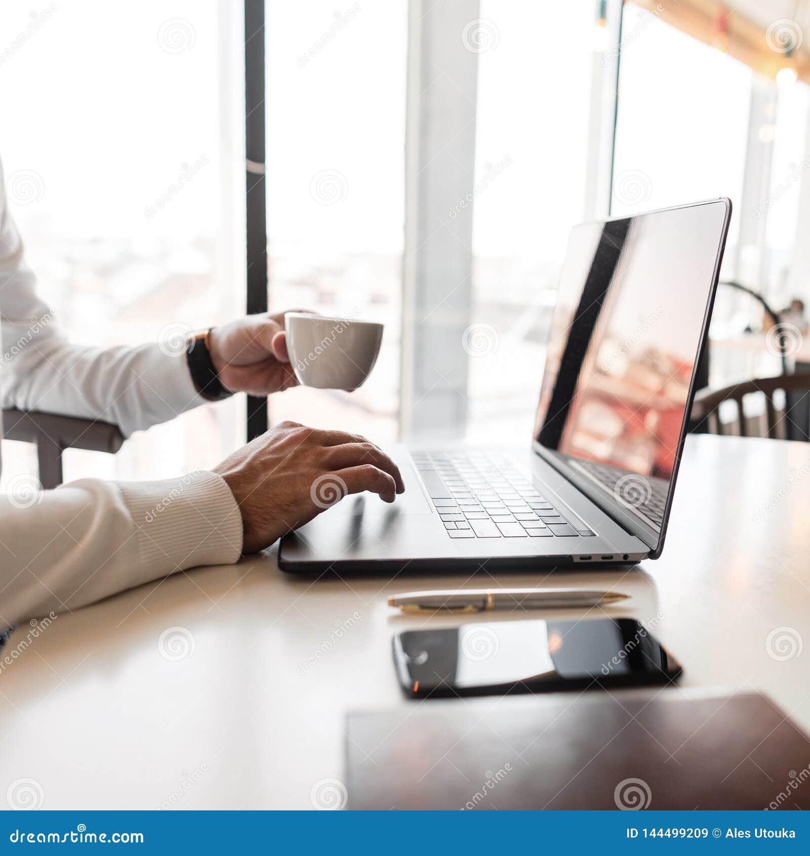 Successful Man Working on a Laptop and Drinking Coffee while Sitting in ...