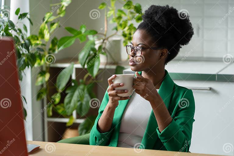 Successful Pensive African American Woman Drinking Coffee Sits At Table