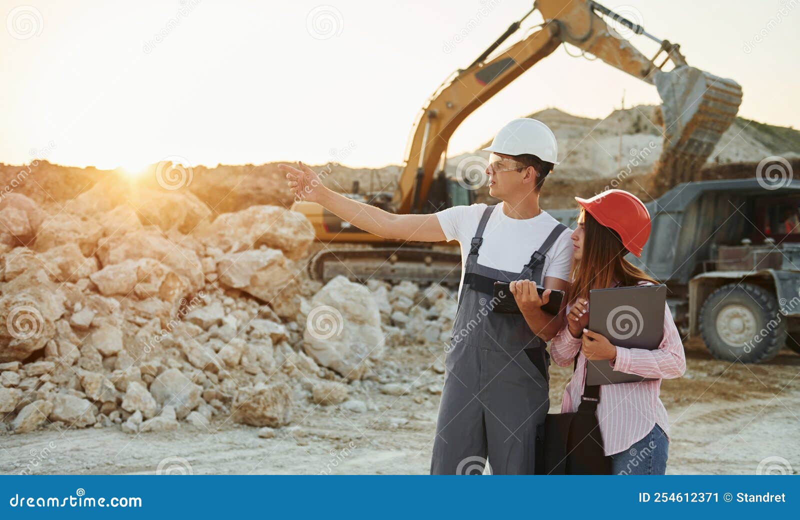 Successful Teamwork. Two People is on the Borrow Pit at Daytime ...