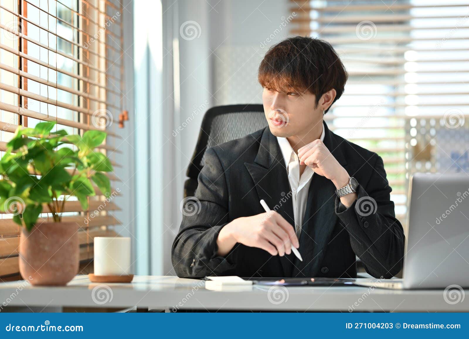 Successful Young Businessman Sitting at Workplace and Looking through ...