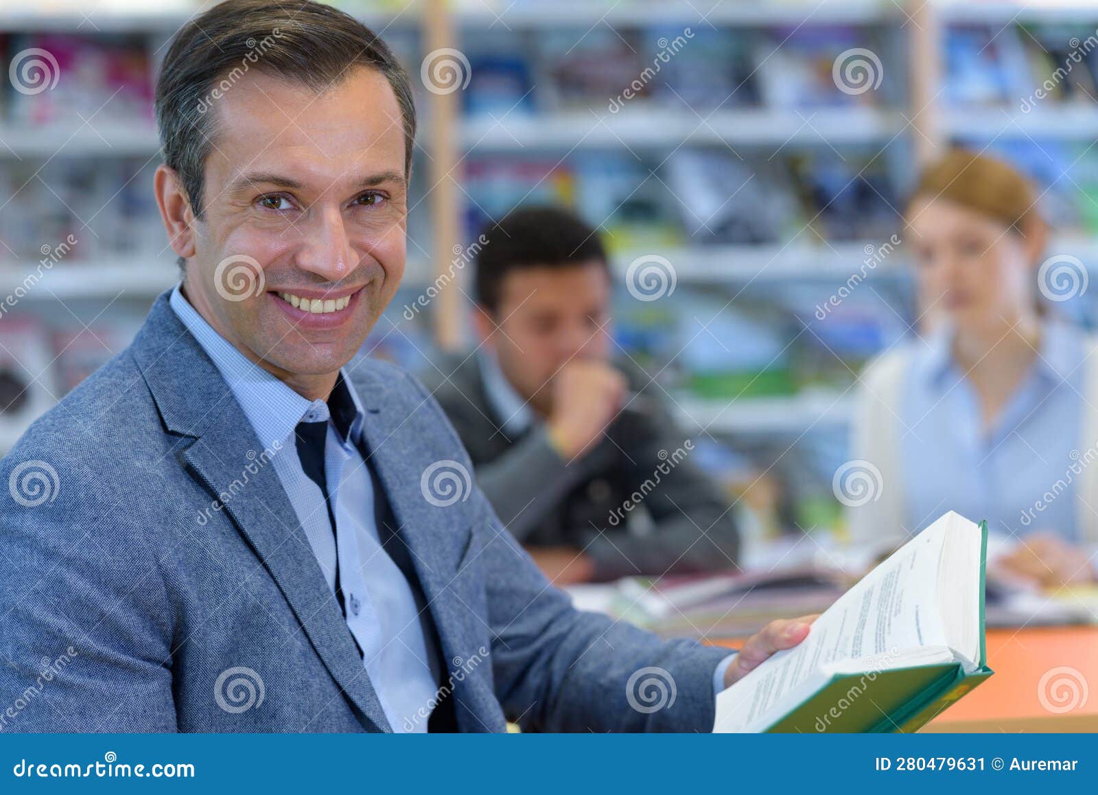 Suited Man Holding Book in Library Stock Image - Image of portrait ...