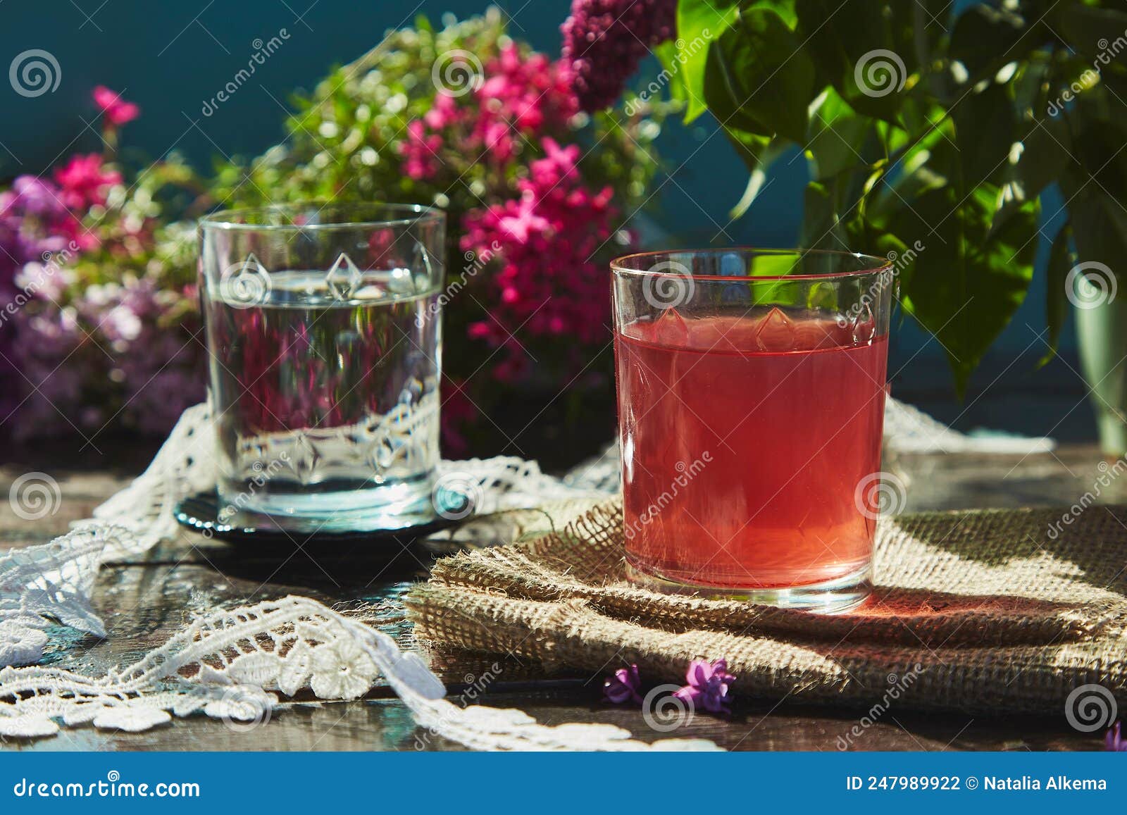 Summer Cocktail Compote And Glass Of Water Among Spring Flowers In The