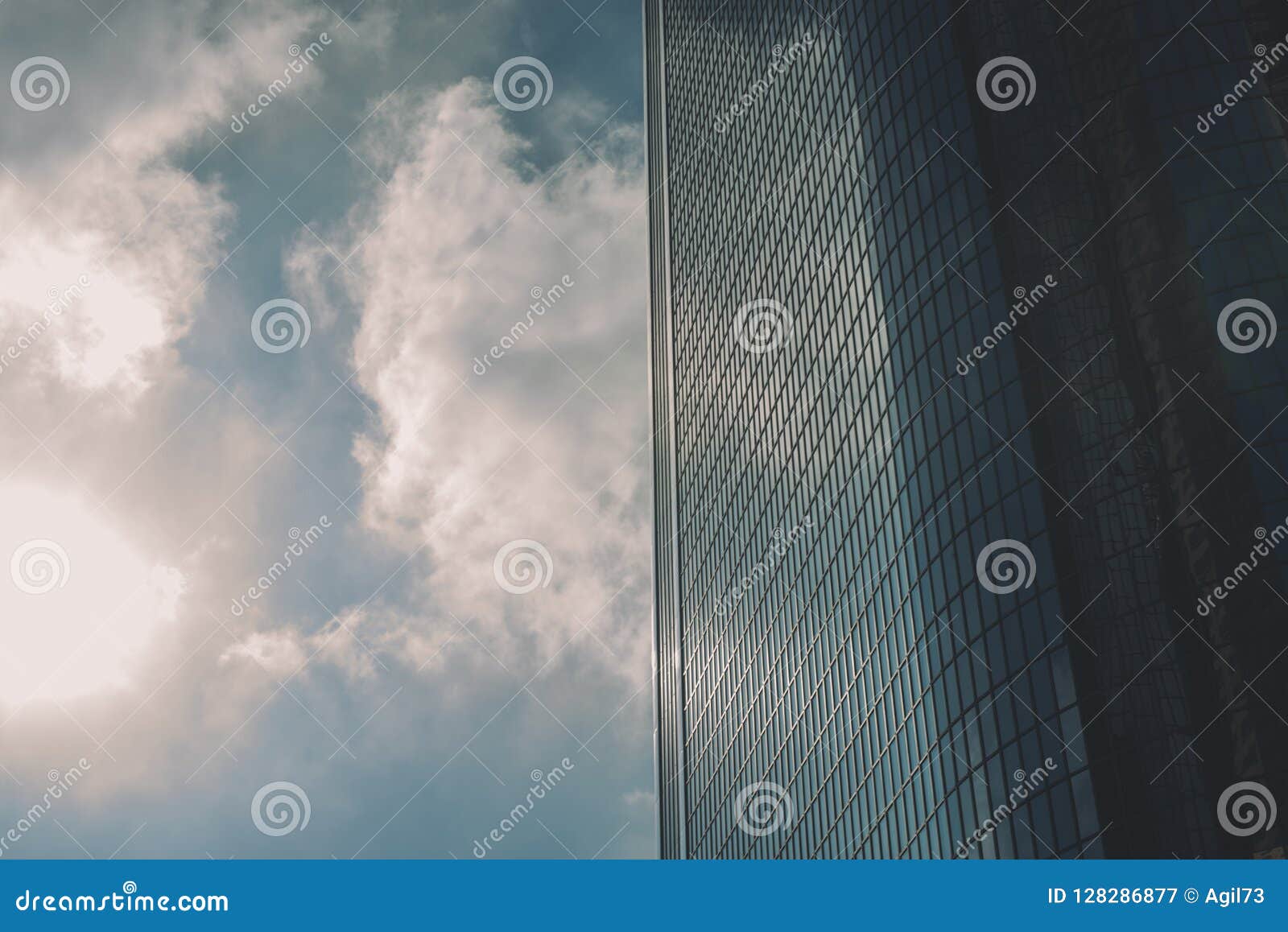 Flat Side of a Glass Sky Scraper with Sun and Clouds Stock Image ...