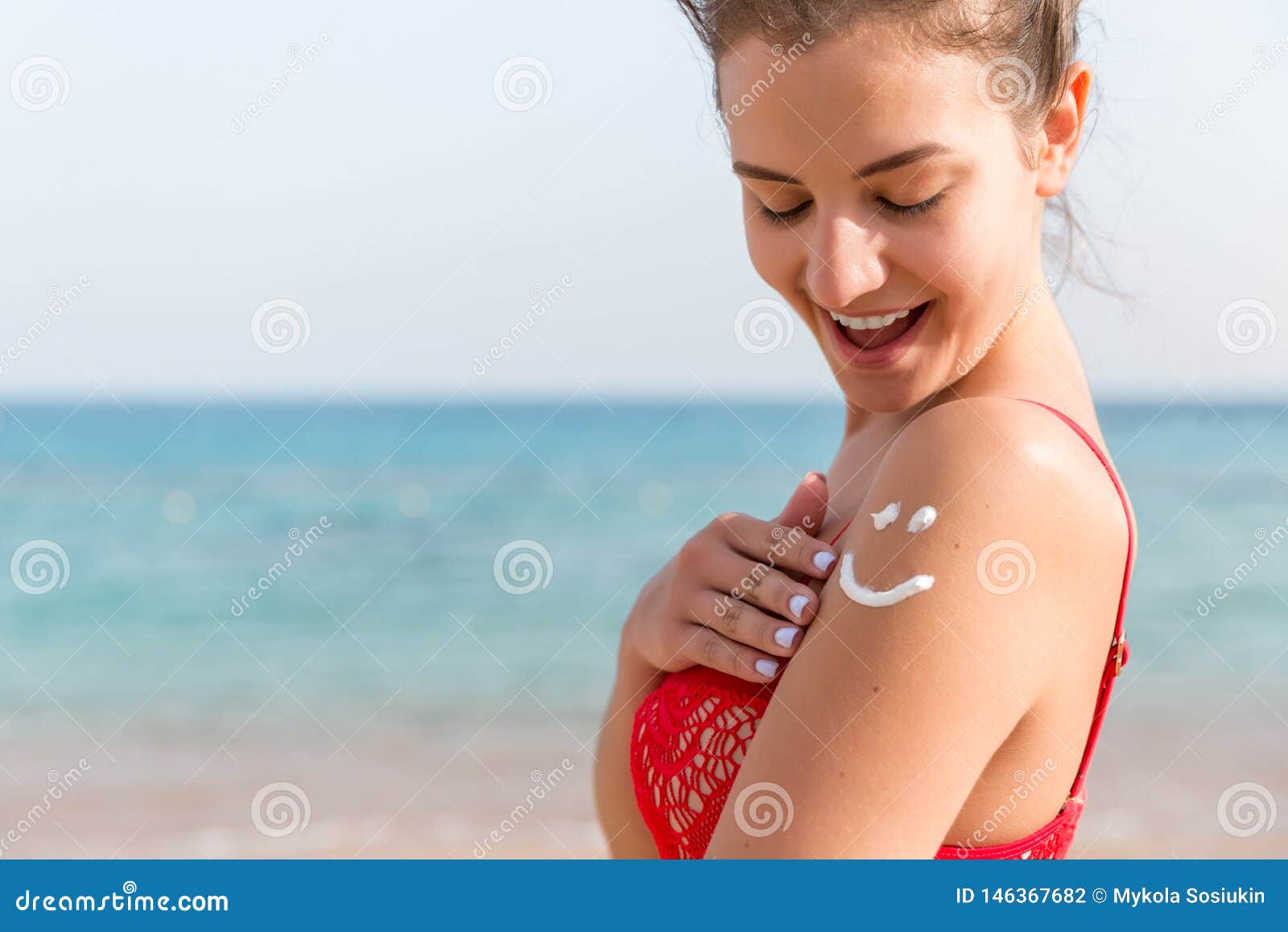 Sun Cream Over Tanned Woman`s Shoulder In The Shape Of Smiling Face