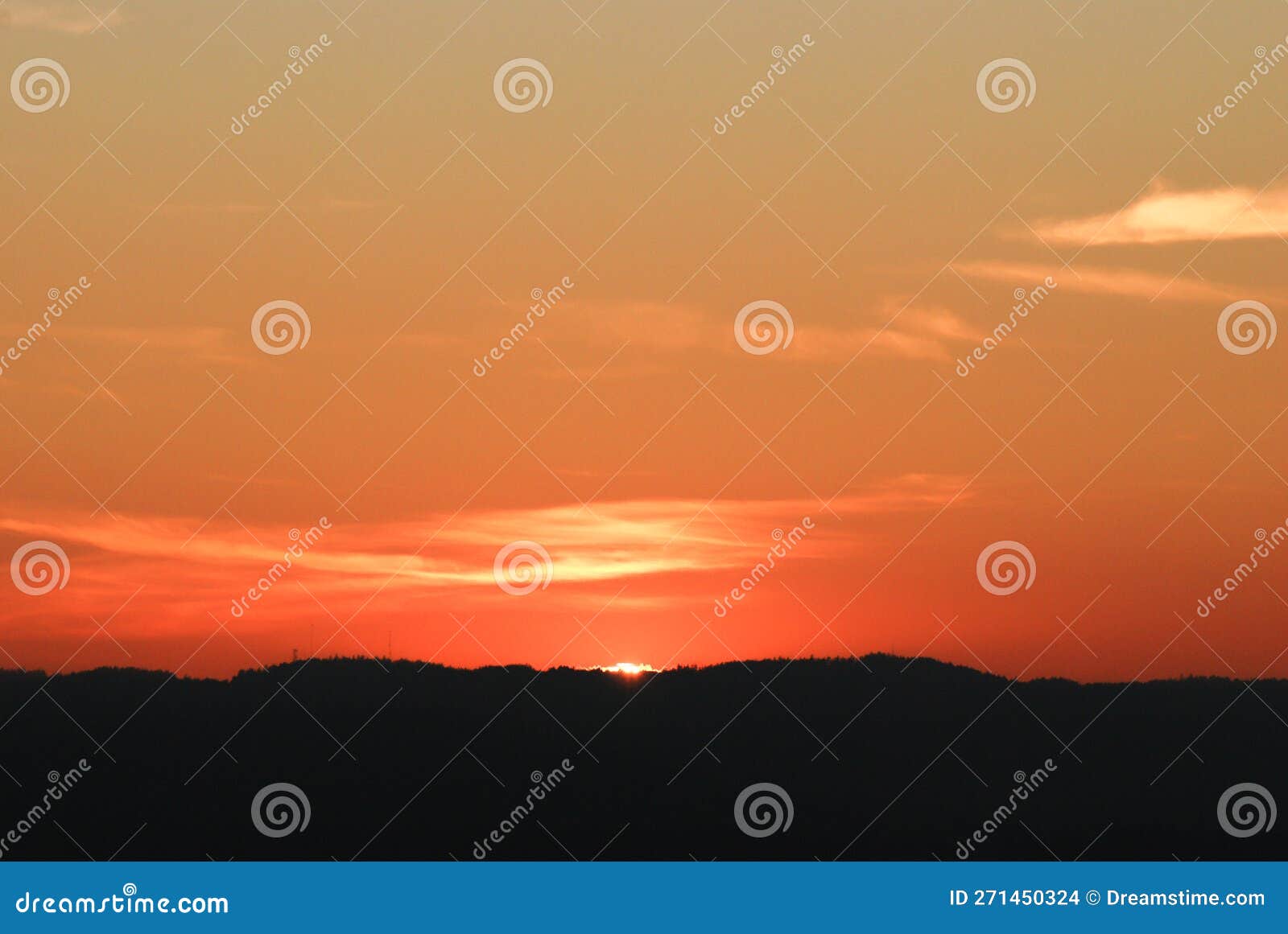 The Sun Dips Down Behind a Forested Ridge on a Hazy Evening on ...