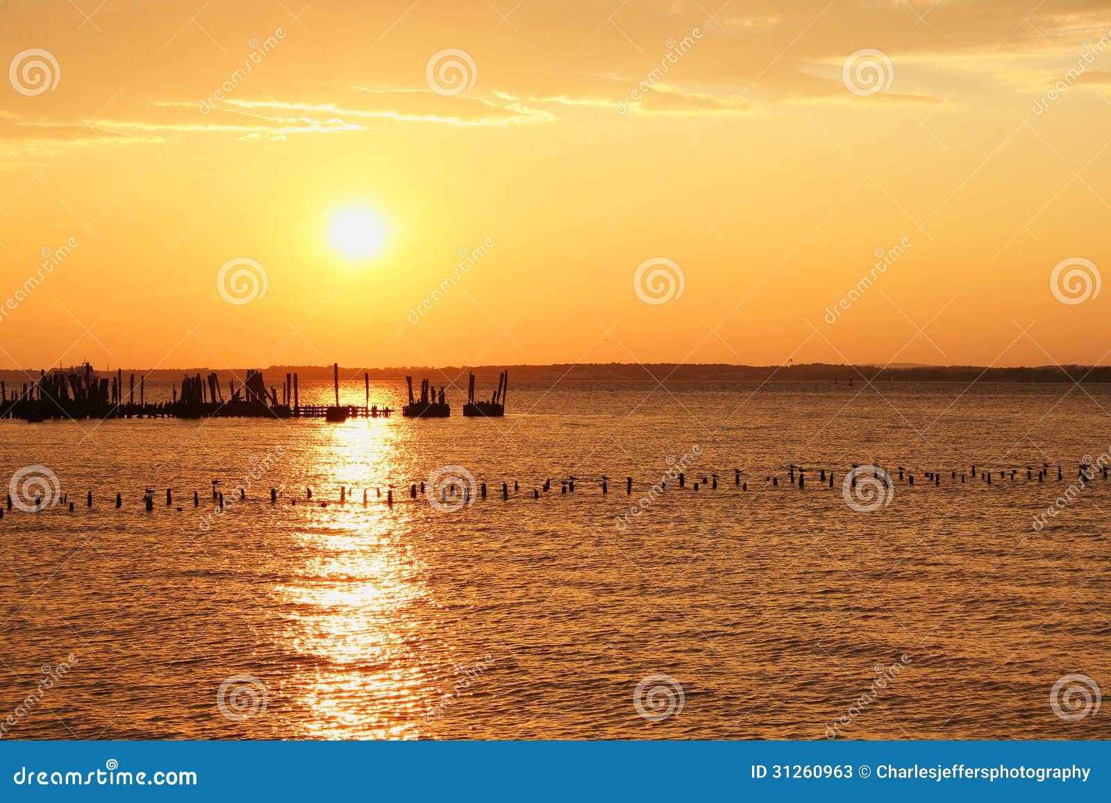 Sun Over Water with Pilings and Clouds Stock Image - Image of ocean ...