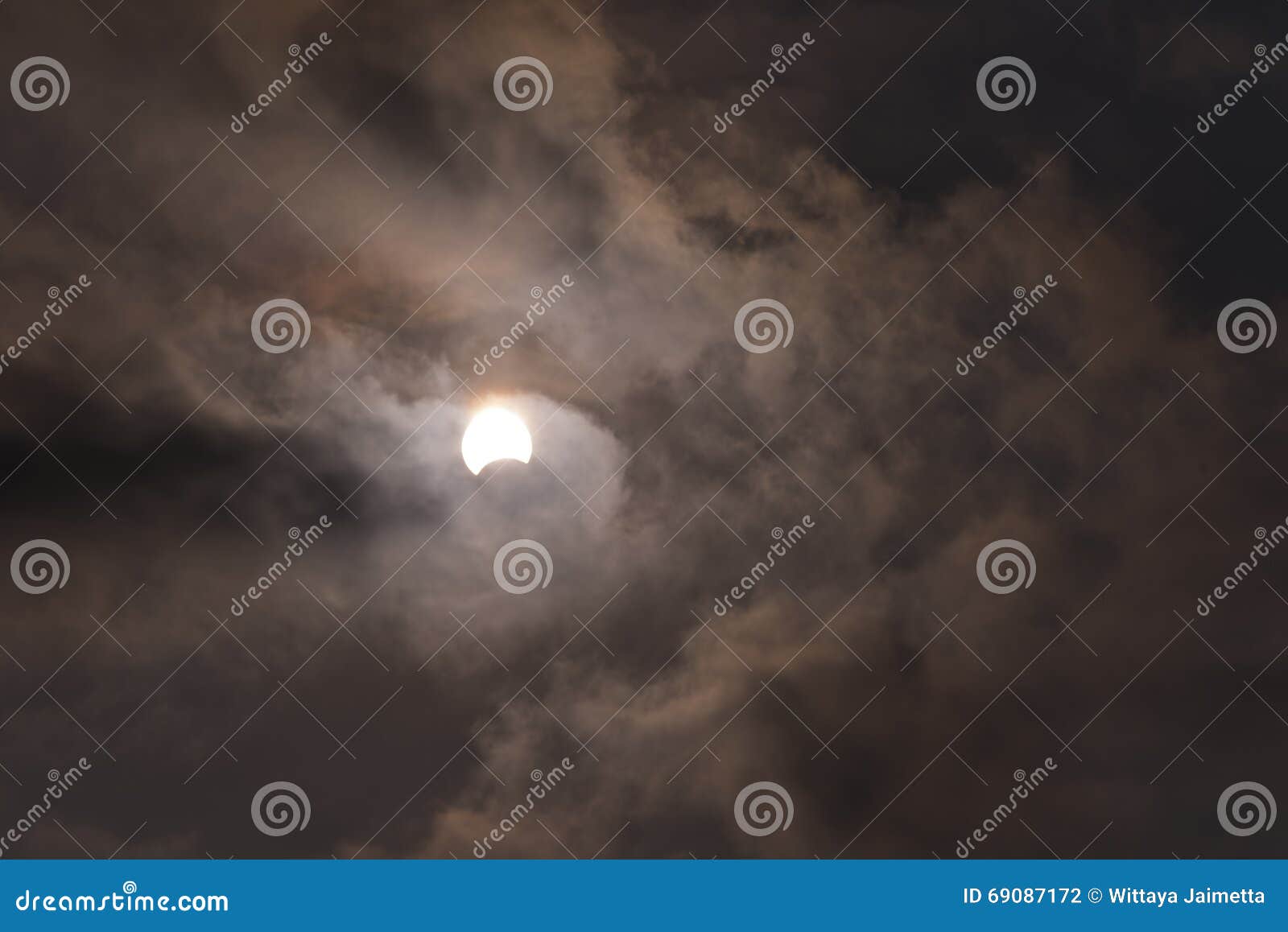 The Sun during a Partial Solar Eclipse with Dark Clouds . Stock Photo ...