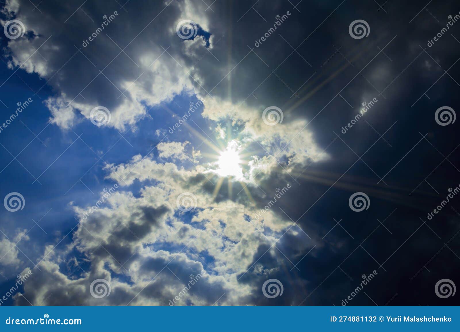 The Sun Rays Break through a Thundercloud on a Blue Sky. Stock Photo ...
