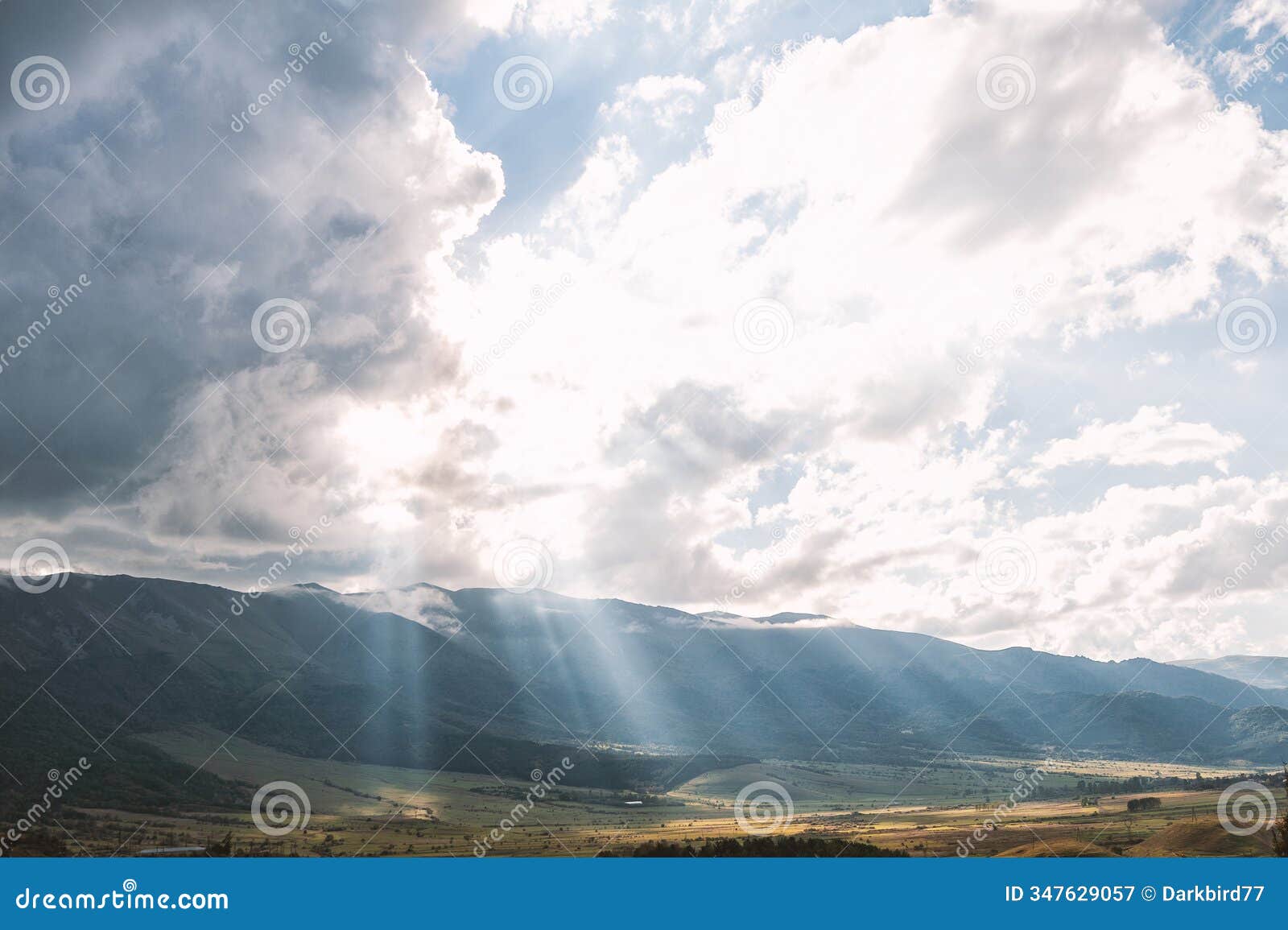 Sun Rays Breaking through Clouds, Illuminating a Valley and Mountains Stock Image - Image of ...