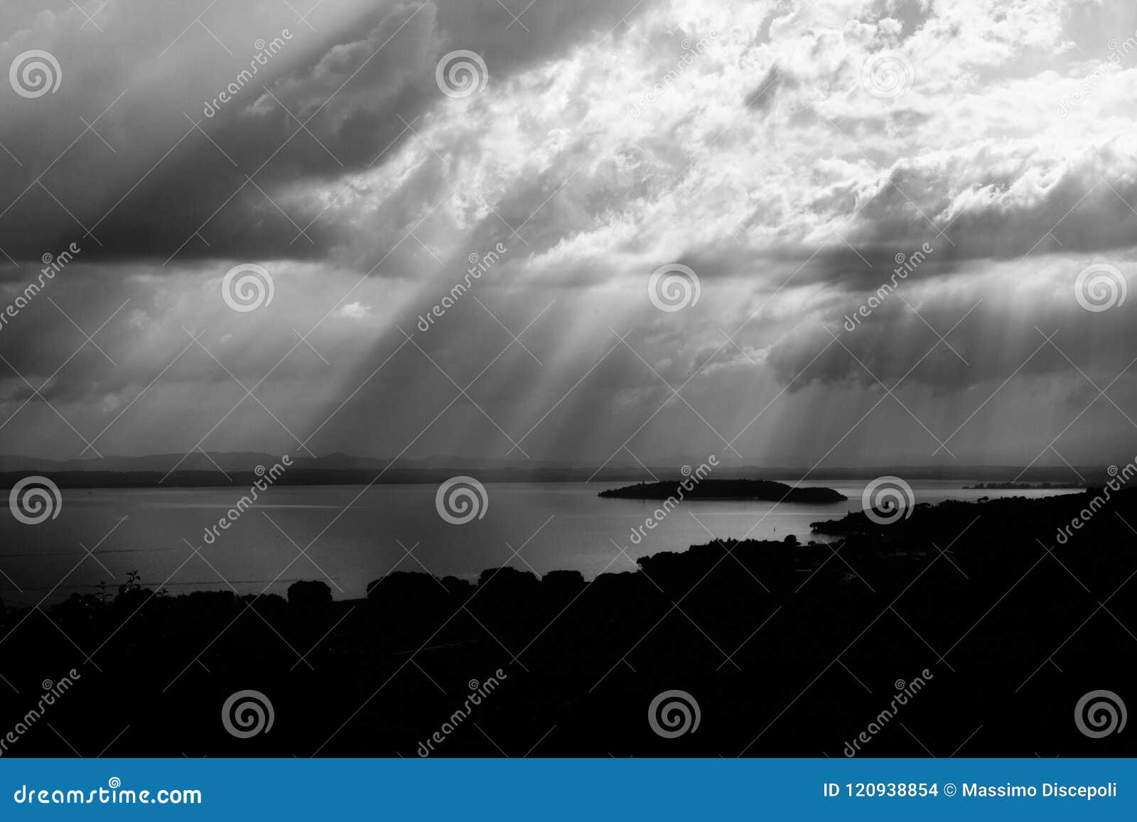 Sun Rays Coming Out through the Clouds Over an Island on a Lake Stock ...