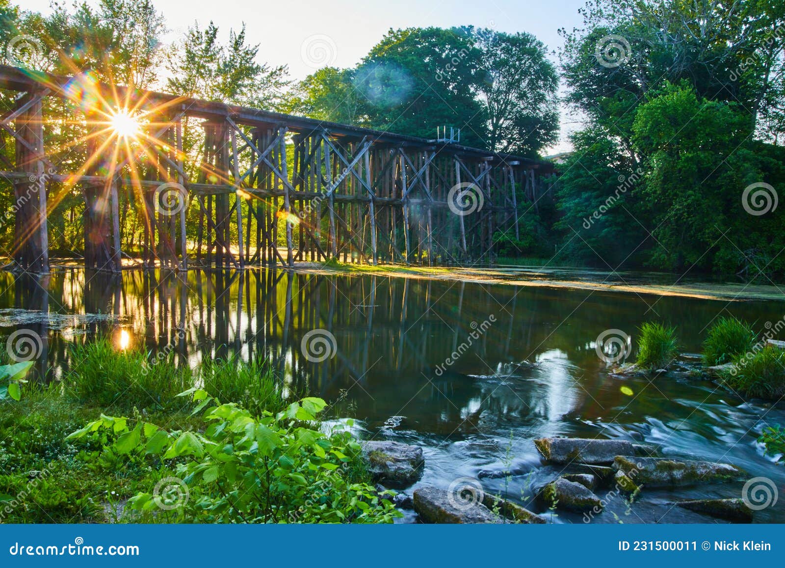 Sun Rays through Old Wood Beam Railroad Bridge in Peaceful River Stock ...