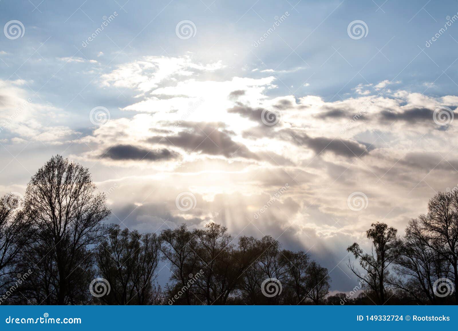Sun Rays from Behind the Clouds Over the Trees Stock Photo - Image of ...