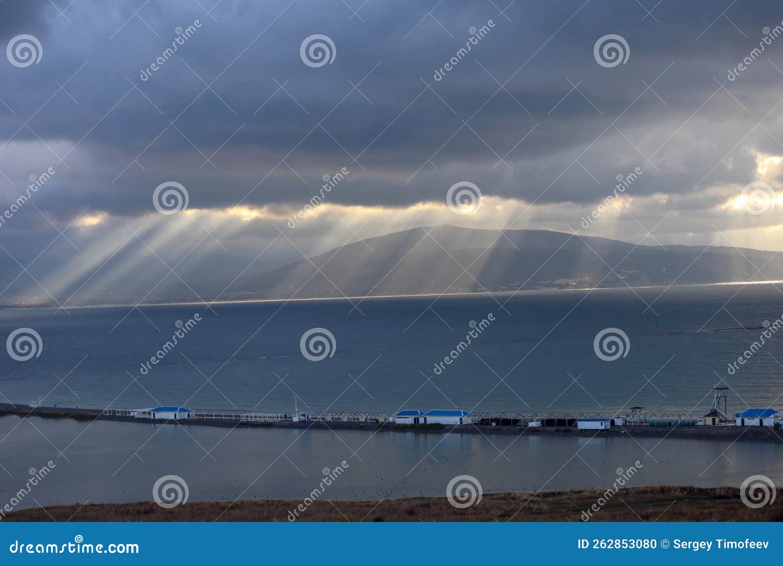 The Sun Rays Shine through the Clouds on the Sea Surface Stock Photo ...