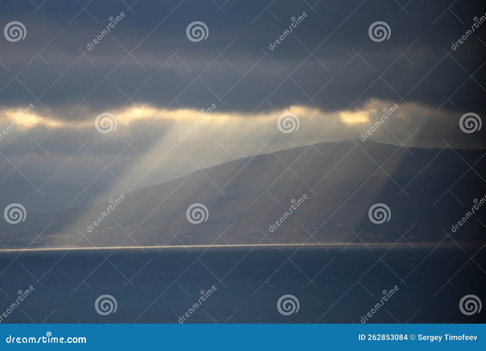 The Sun Rays Shine through the Clouds on the Sea Surface Stock Photo ...