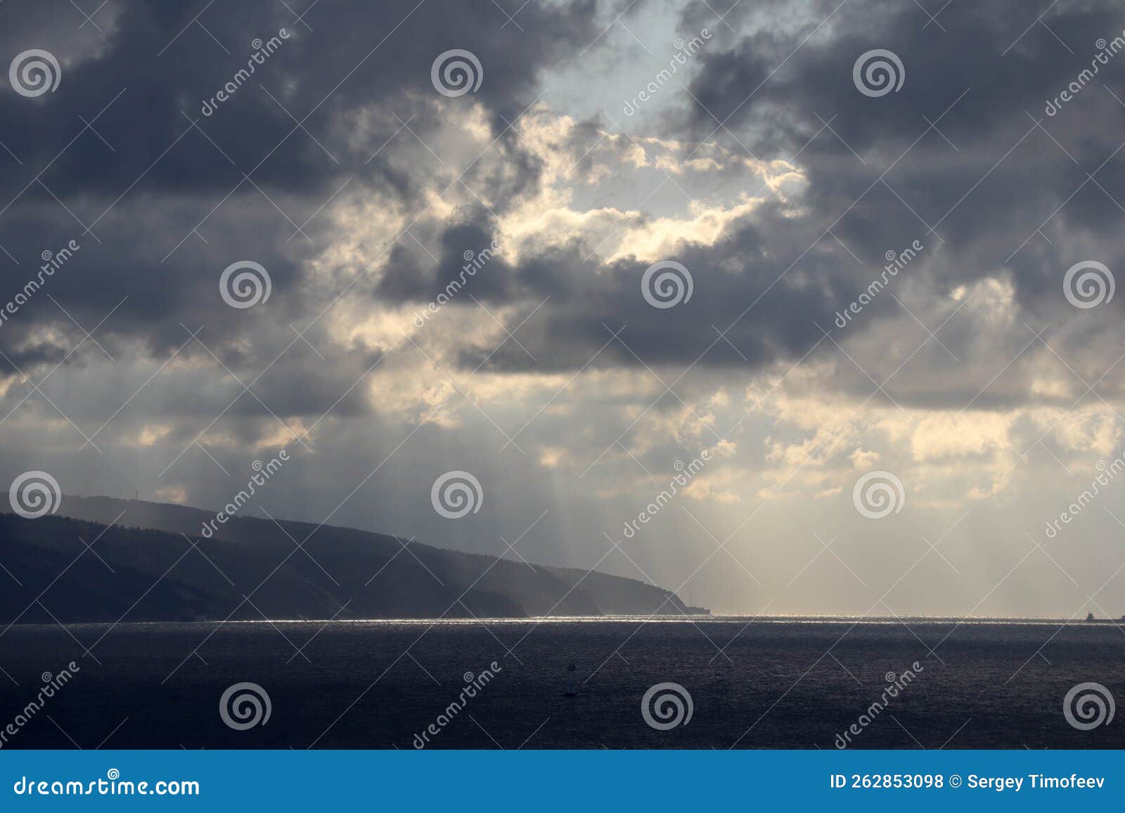 The Sun Rays Shine through the Clouds on the Sea Surface Stock Photo ...