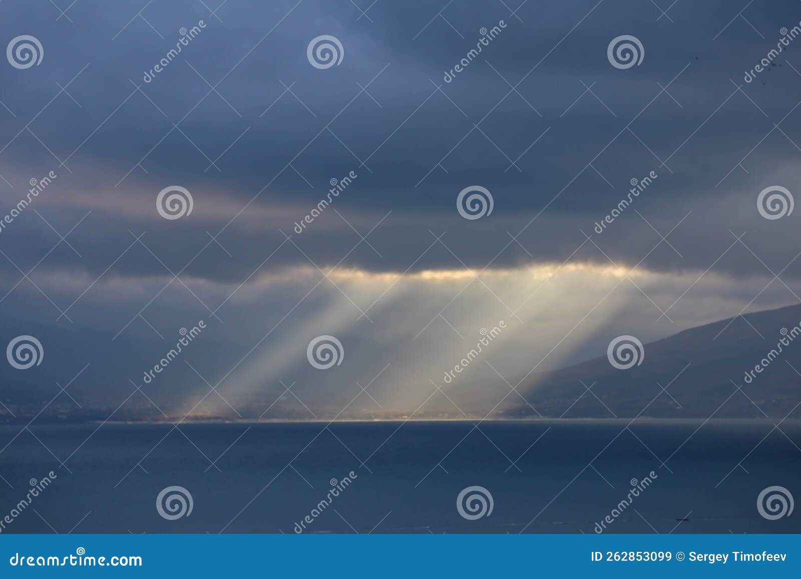 The Sun Rays Shine through the Clouds on the Sea Surface Stock Image ...
