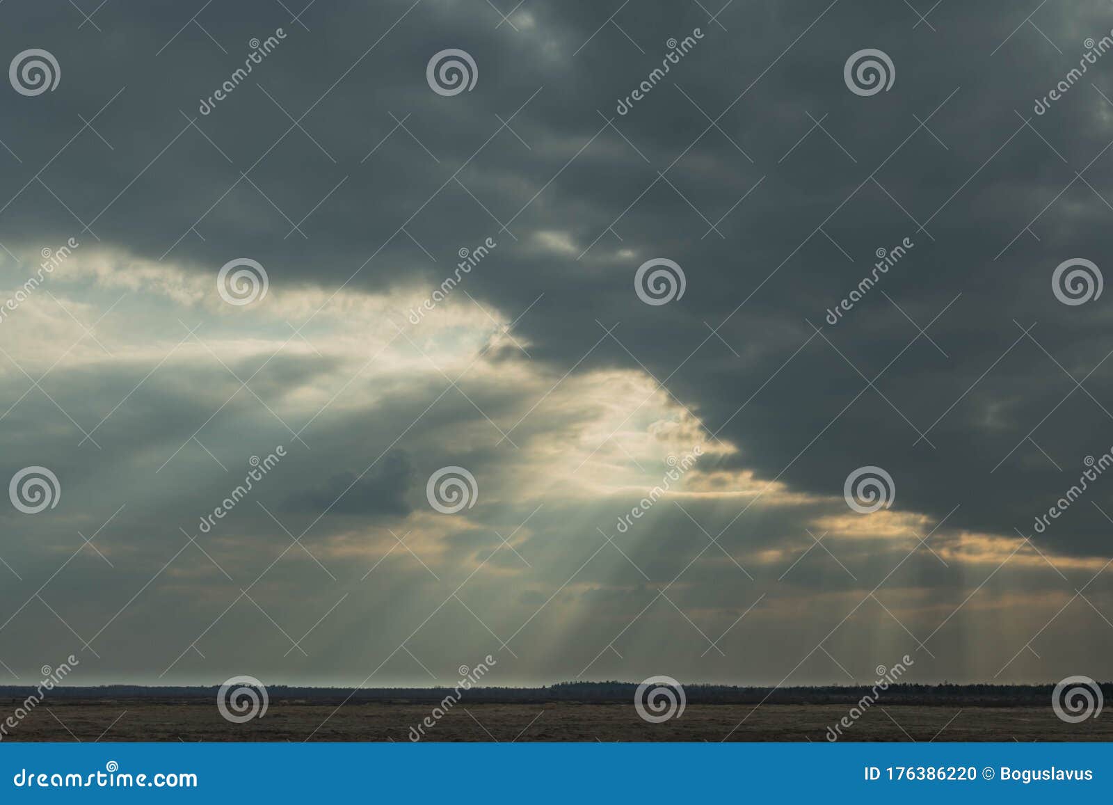 Sun Rays Streaming Down the Streaks of Dark Clouds. Stock Photo - Image ...