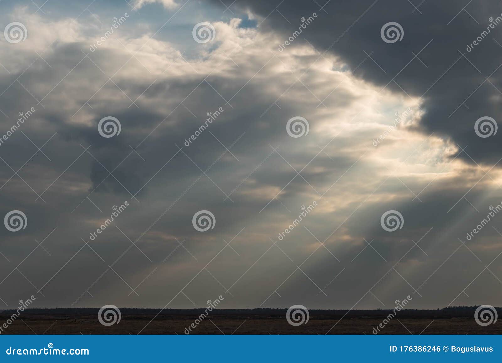 Sun Rays Streaming Down the Streaks of Dark Clouds. Stock Photo - Image ...