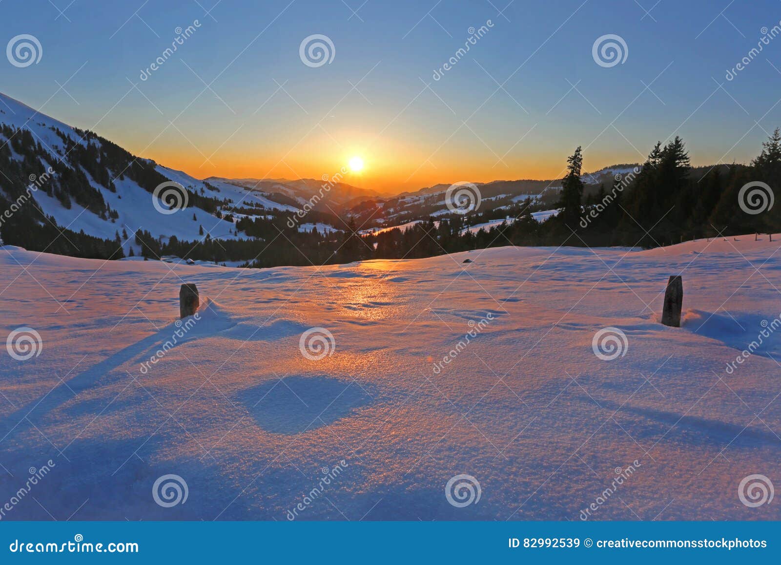 Sun Rising In Horizon Over Snow Coated Mountains Picture. Image: 82992539