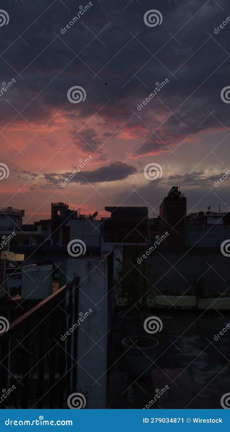 The Sun Sets in the Clouds Above a Rooftop at Dusk Stock Image - Image ...