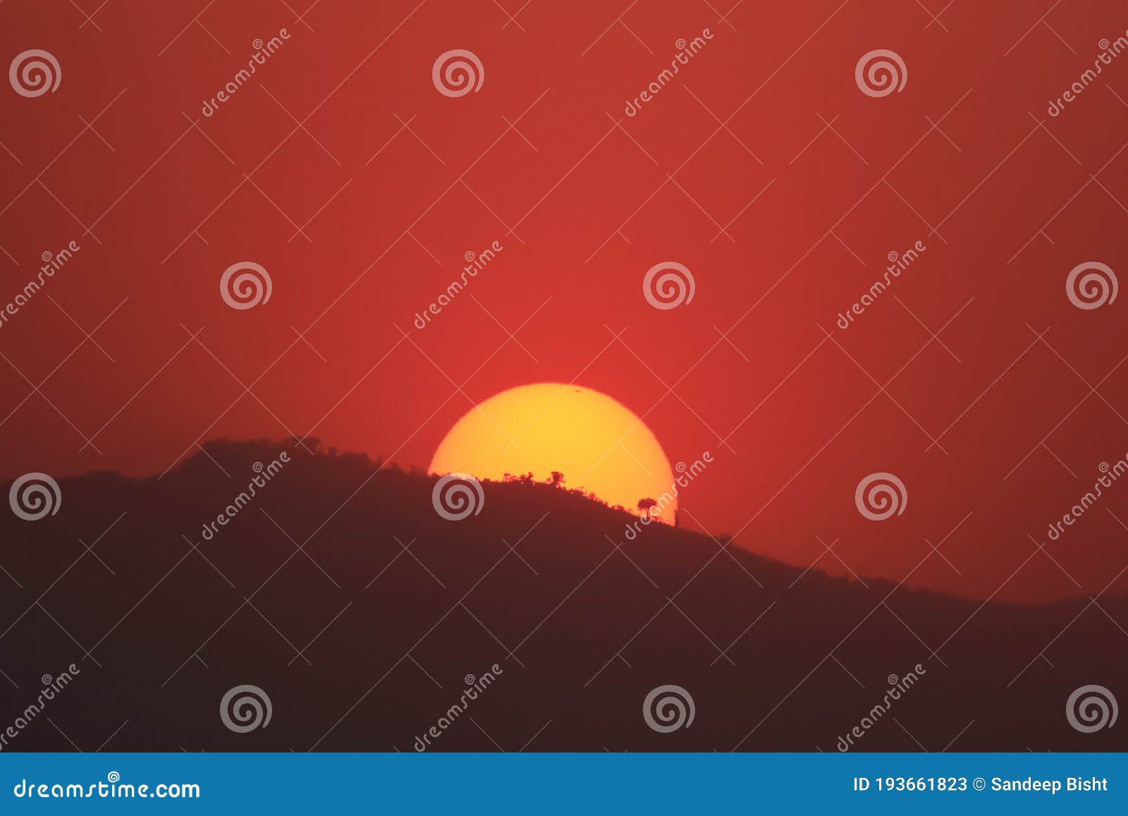 Sun setting behind a hill stock image. Image of sundown - 193661823