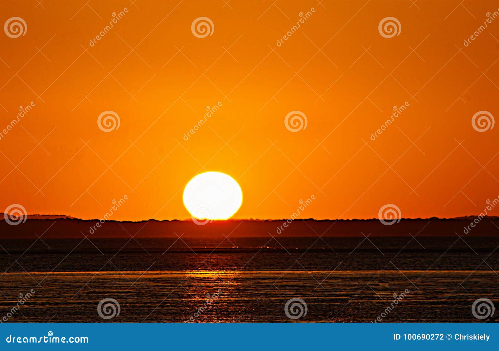 Sun setting in horizon stock photo. Image of orange - 100690272