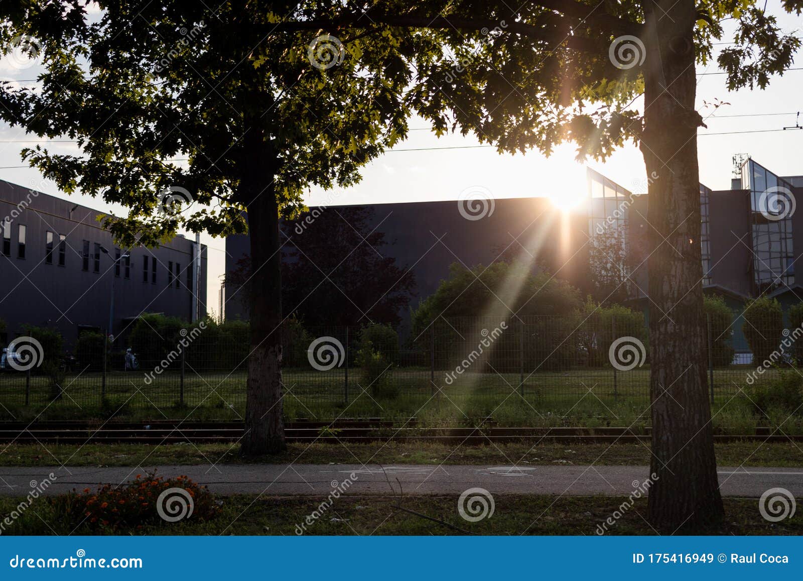 Sun Setting Behind Office Building with Trees in Front Stock Image ...