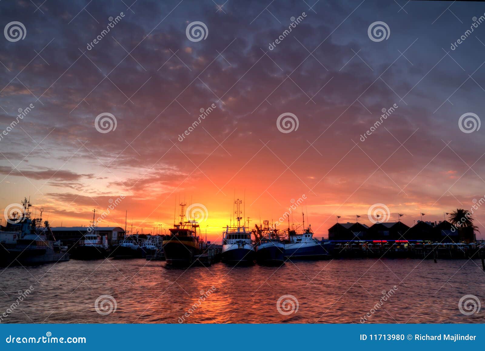 Sun Setting between Boats in Freo Harbour Stock Photo - Image of sunset ...