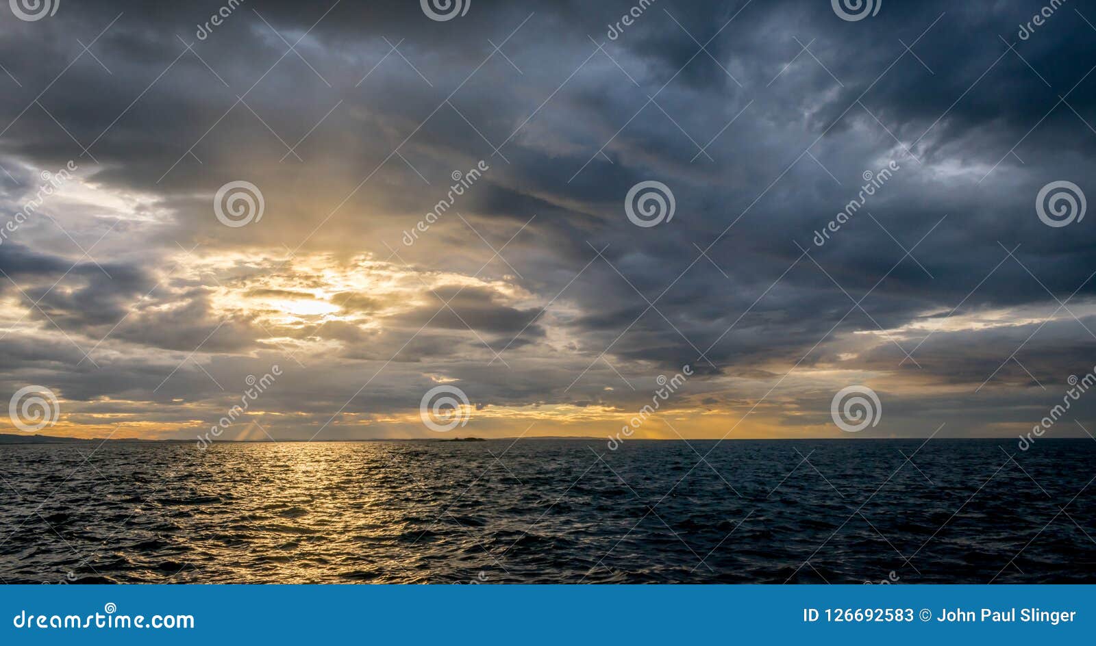 Storm Clouds with the Sun Setting and Sun Rays Over the Ocean. Stock ...